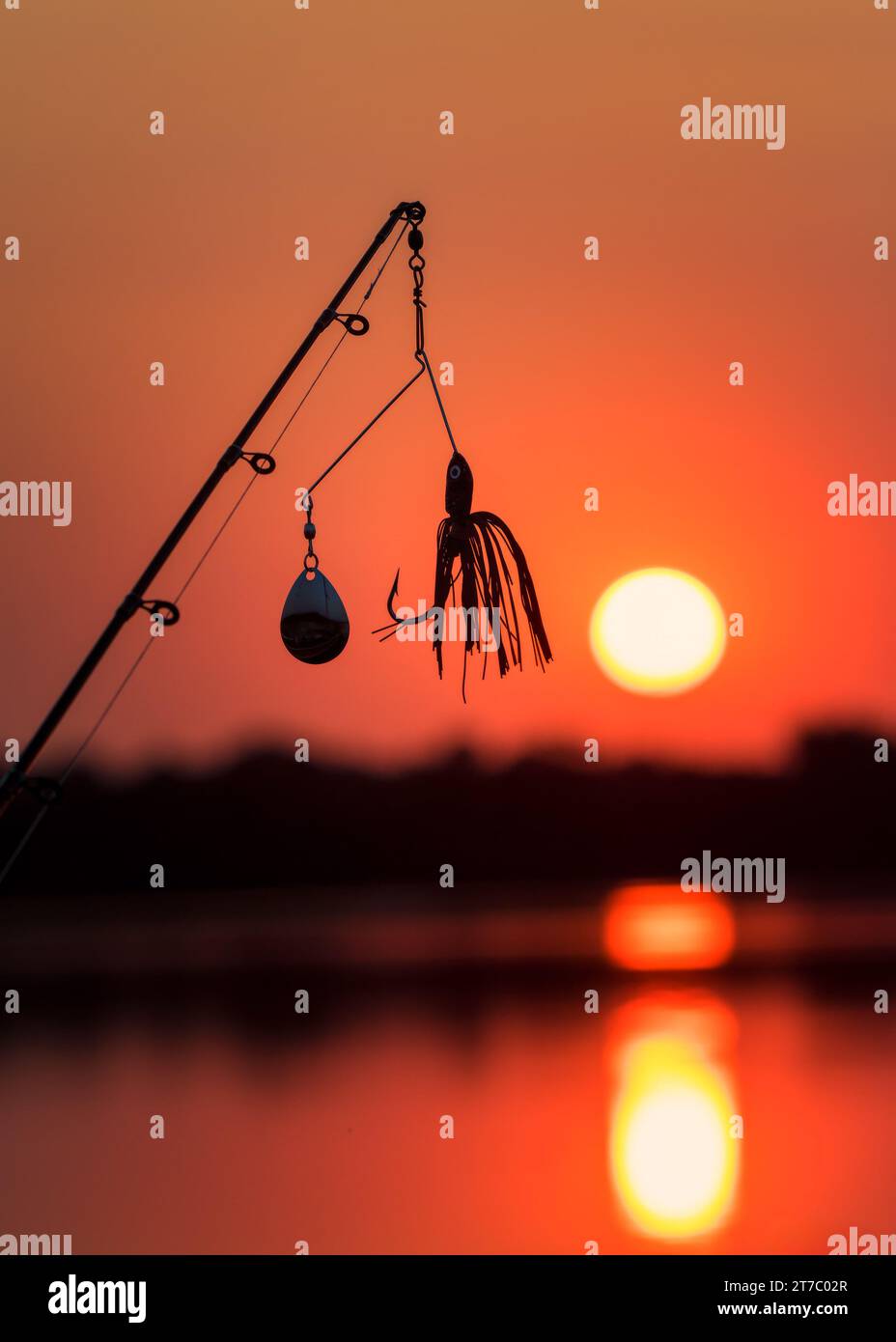 Fishing rod and lure silhouette with golden hour setting sun as ...