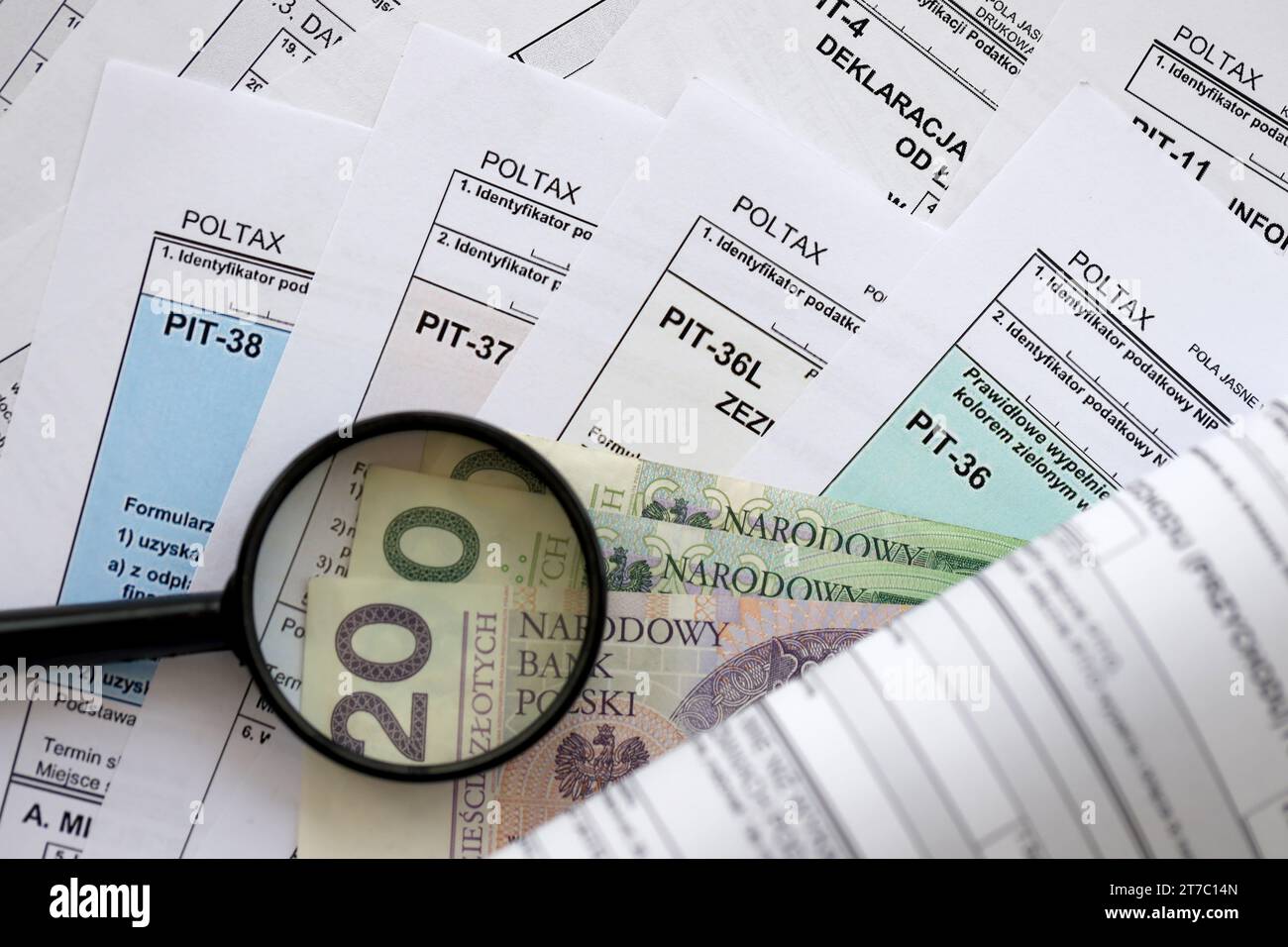 Polish zloty money and magnifying glass on big amount of polish tax ...