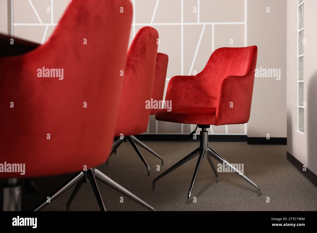 Stylish red office chairs and large table in empty conference room ...