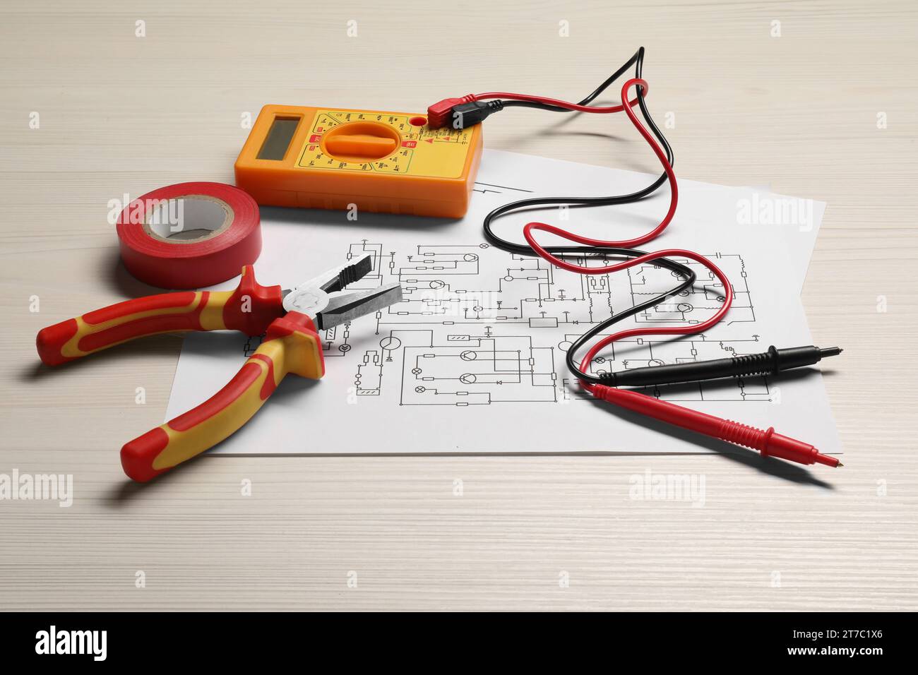Wiring diagrams, digital multimeter and tools on white wooden table ...