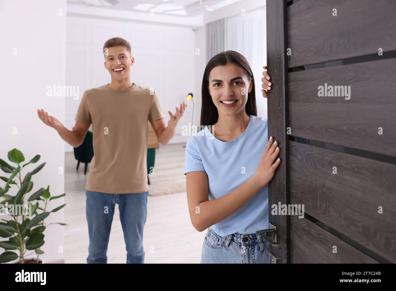 Happy couple welcoming at home. Invitation to come indoors Stock Photo ...