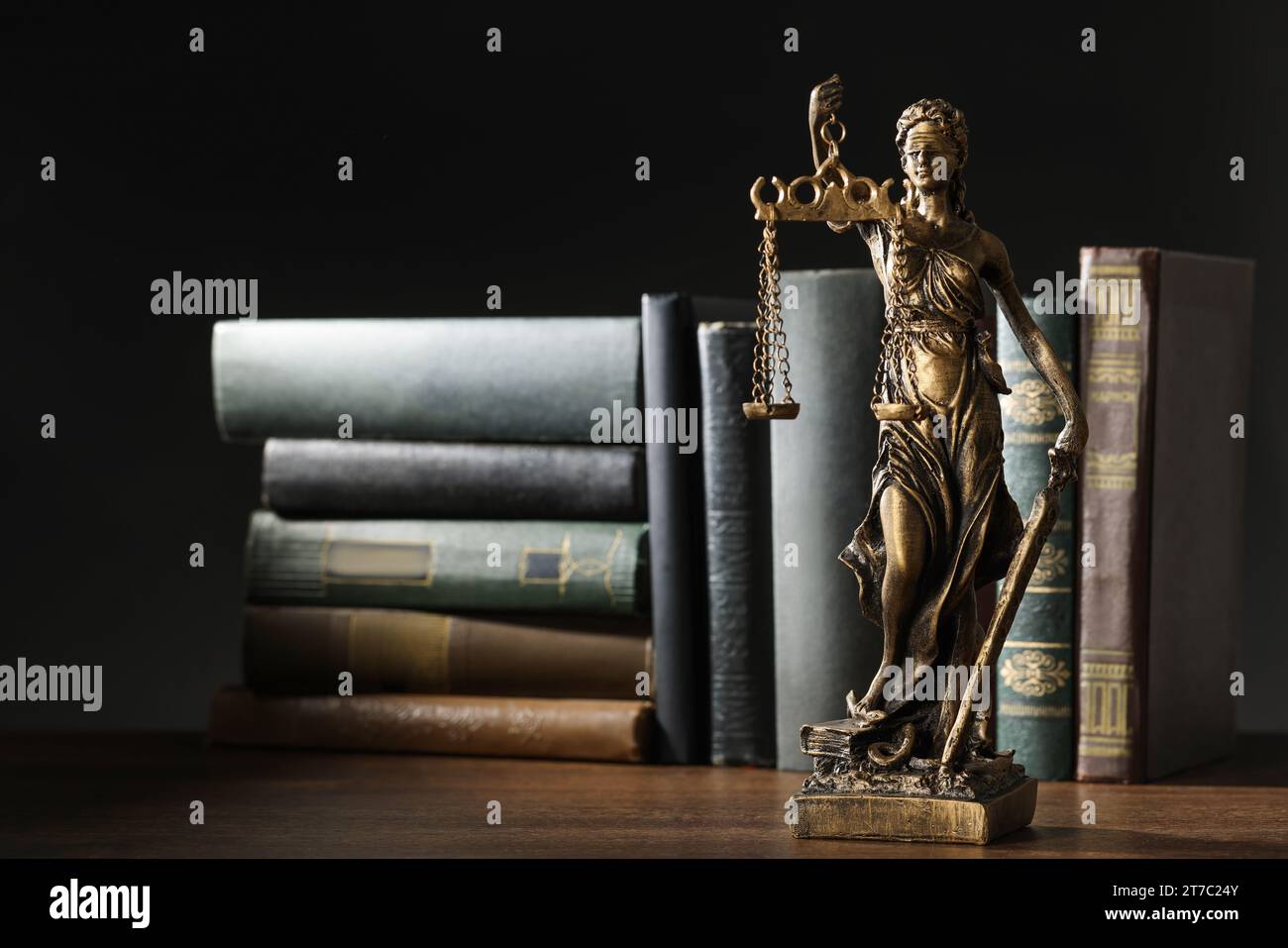 Statue of Lady Justice near books on wooden table, space for text ...