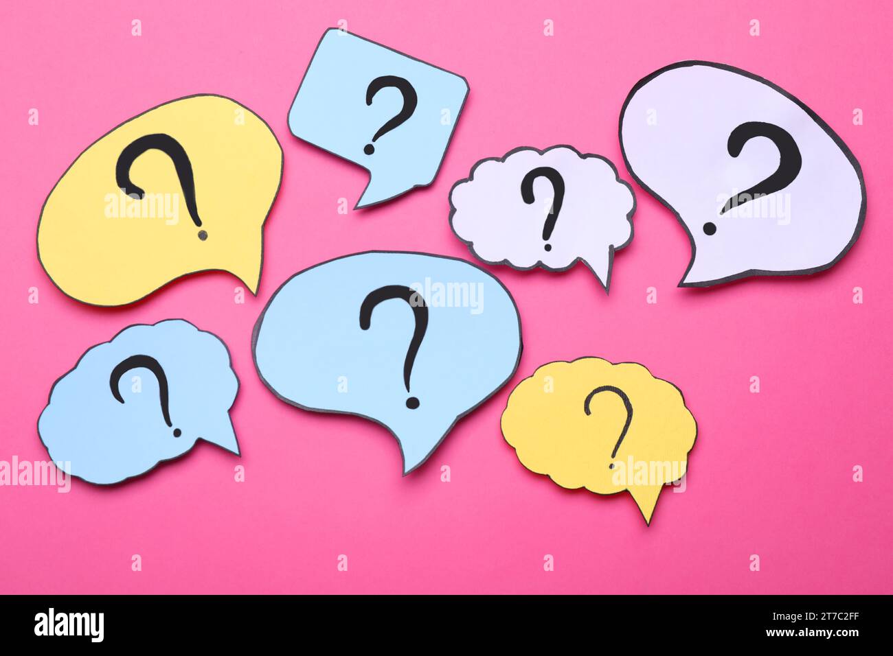 Different paper speech bubbles with question marks on pink background ...