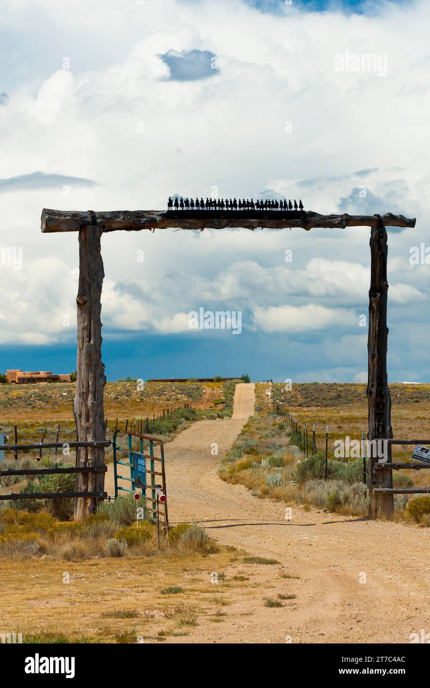 Figures, silhouette, of cowboys and drovers at the entrance to a farm ...