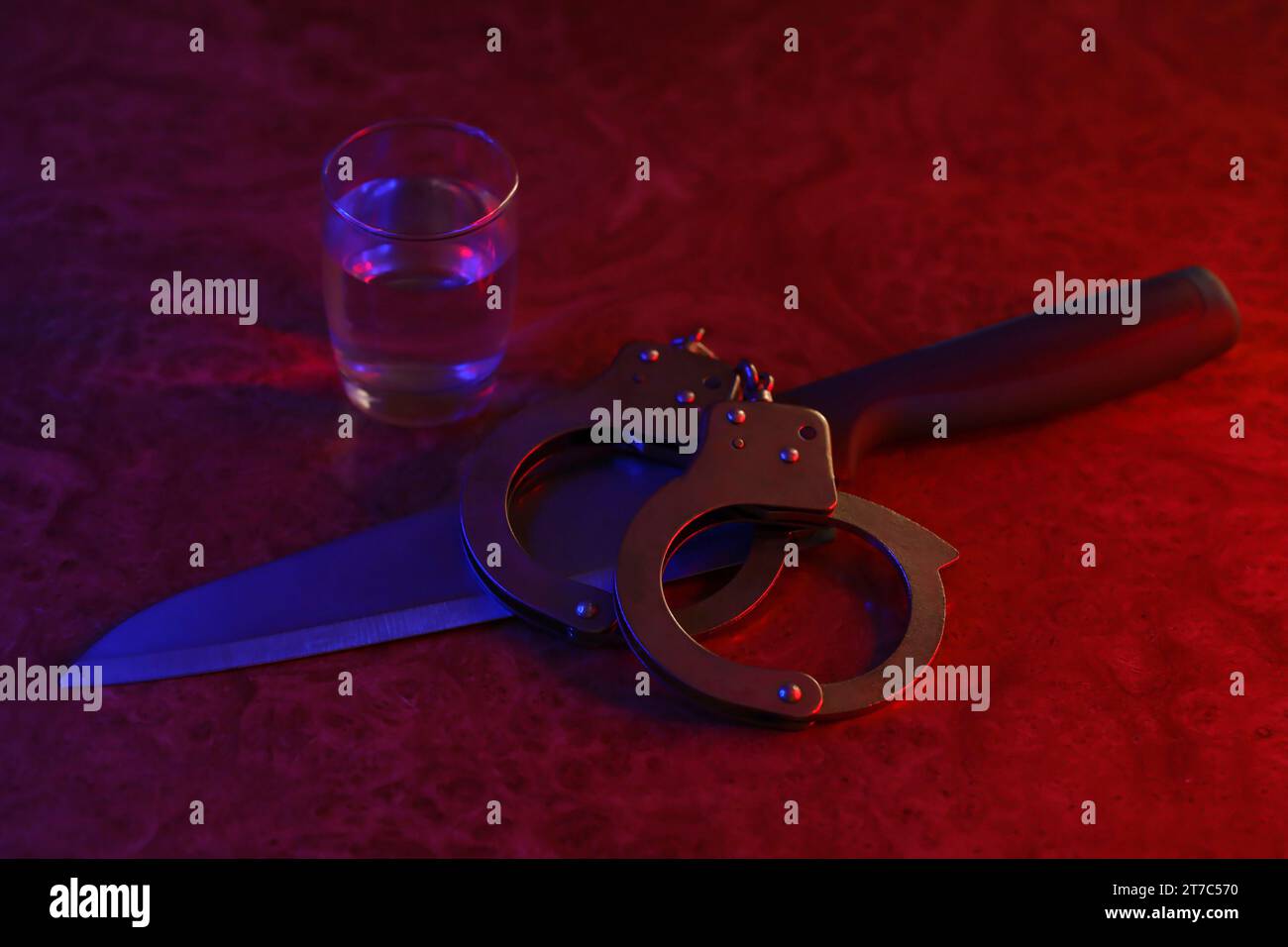 Glass with vodka alcohol drink, knife and handcuffs. Concept of ...