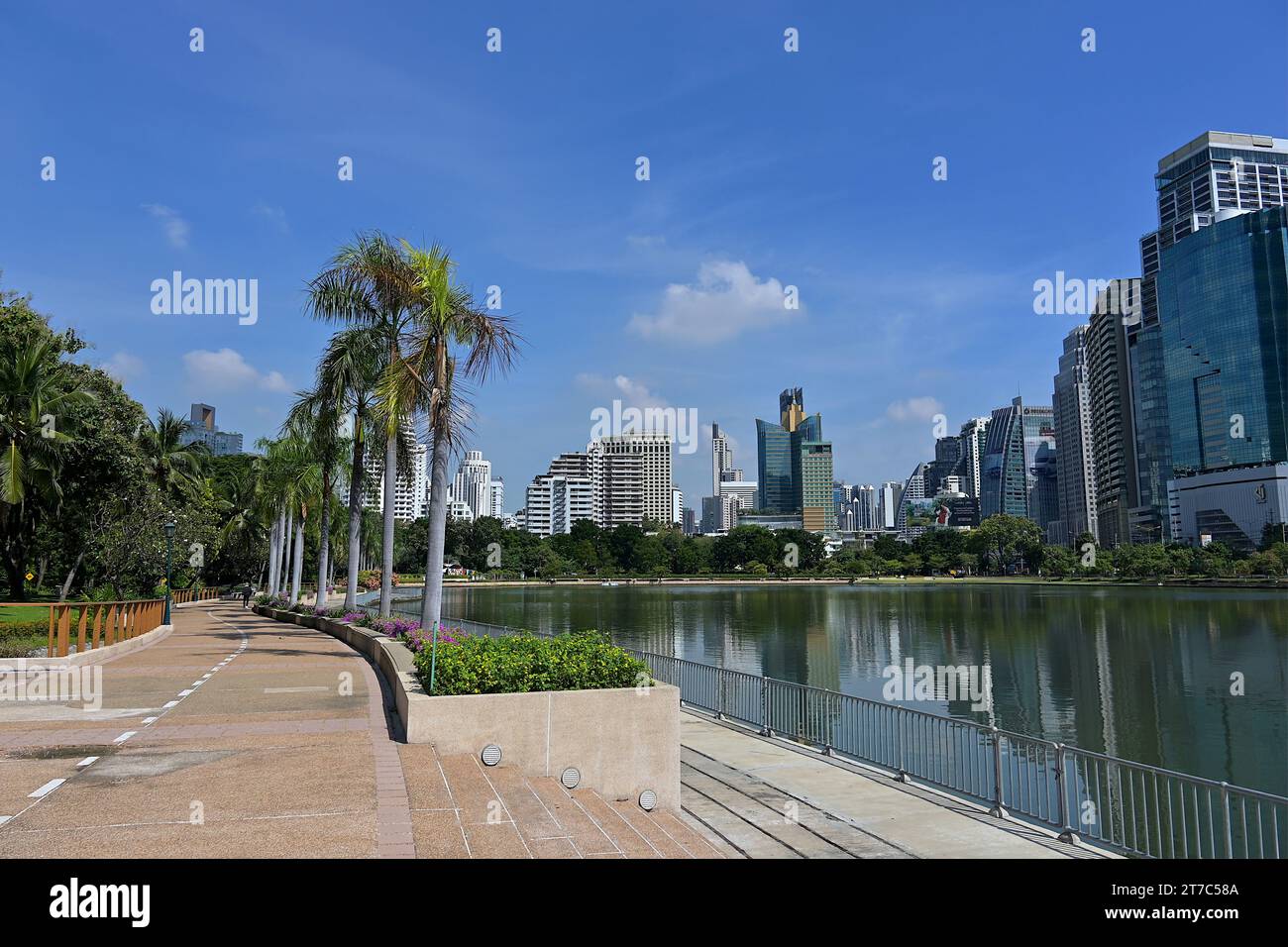 Running track along Lake Ratchada with commercial buildings of ...