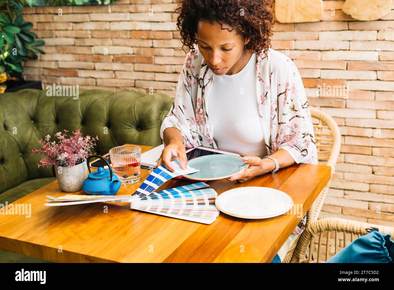 Woman matching color swatch with plate table Stock Photo - Alamy