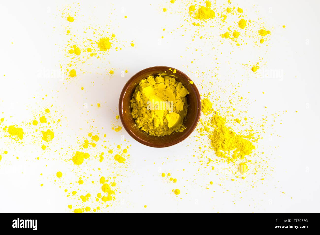 Yellow holi color powder bowl white background Stock Photo - Alamy