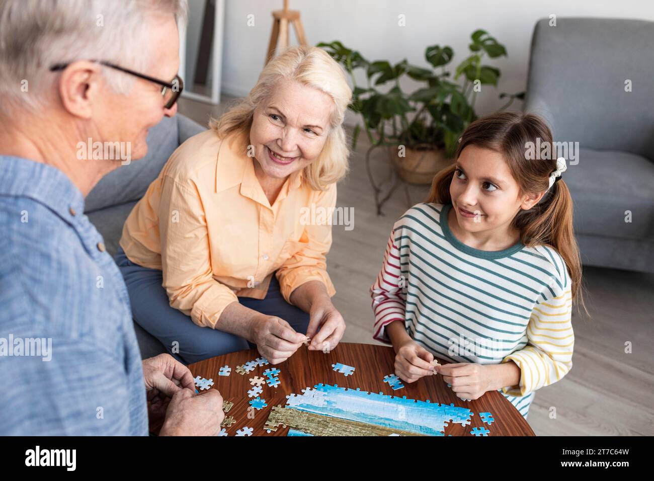 Close up family doing puzzle Stock Photo - Alamy
