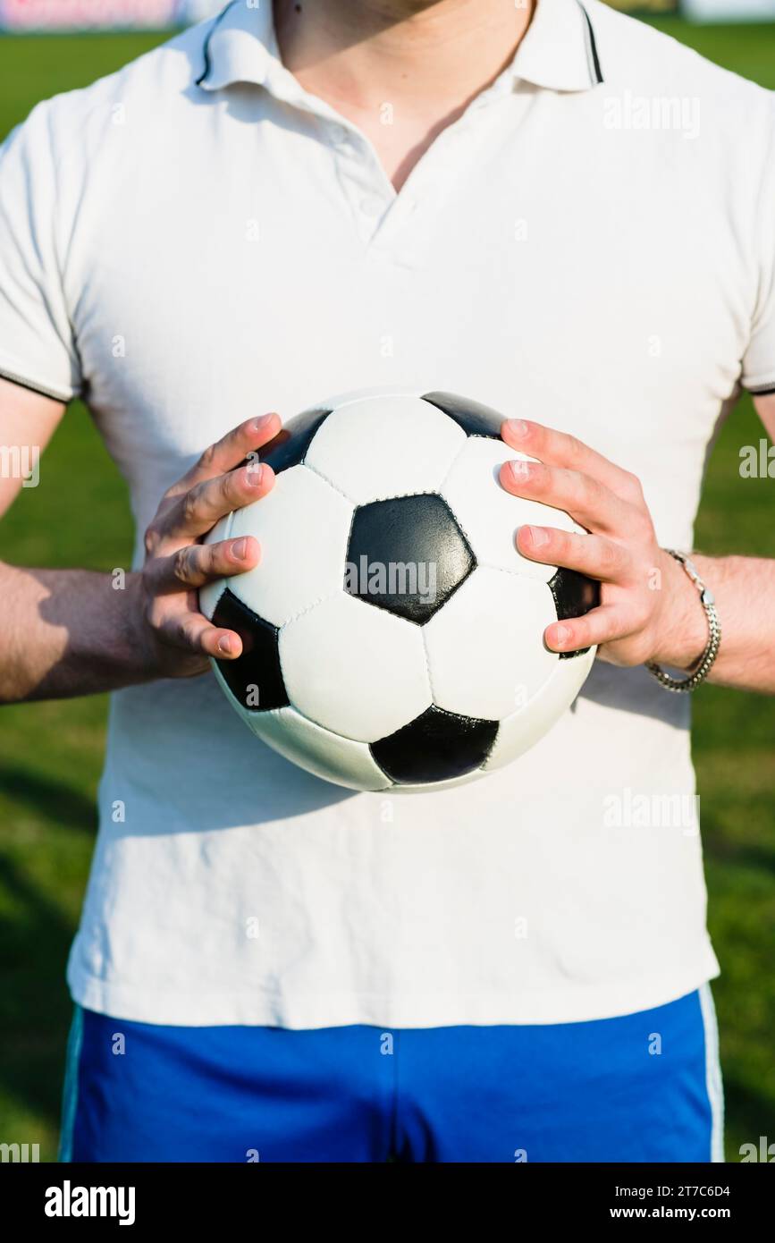 Crop sportsman holding new soccer ball Stock Photo - Alamy