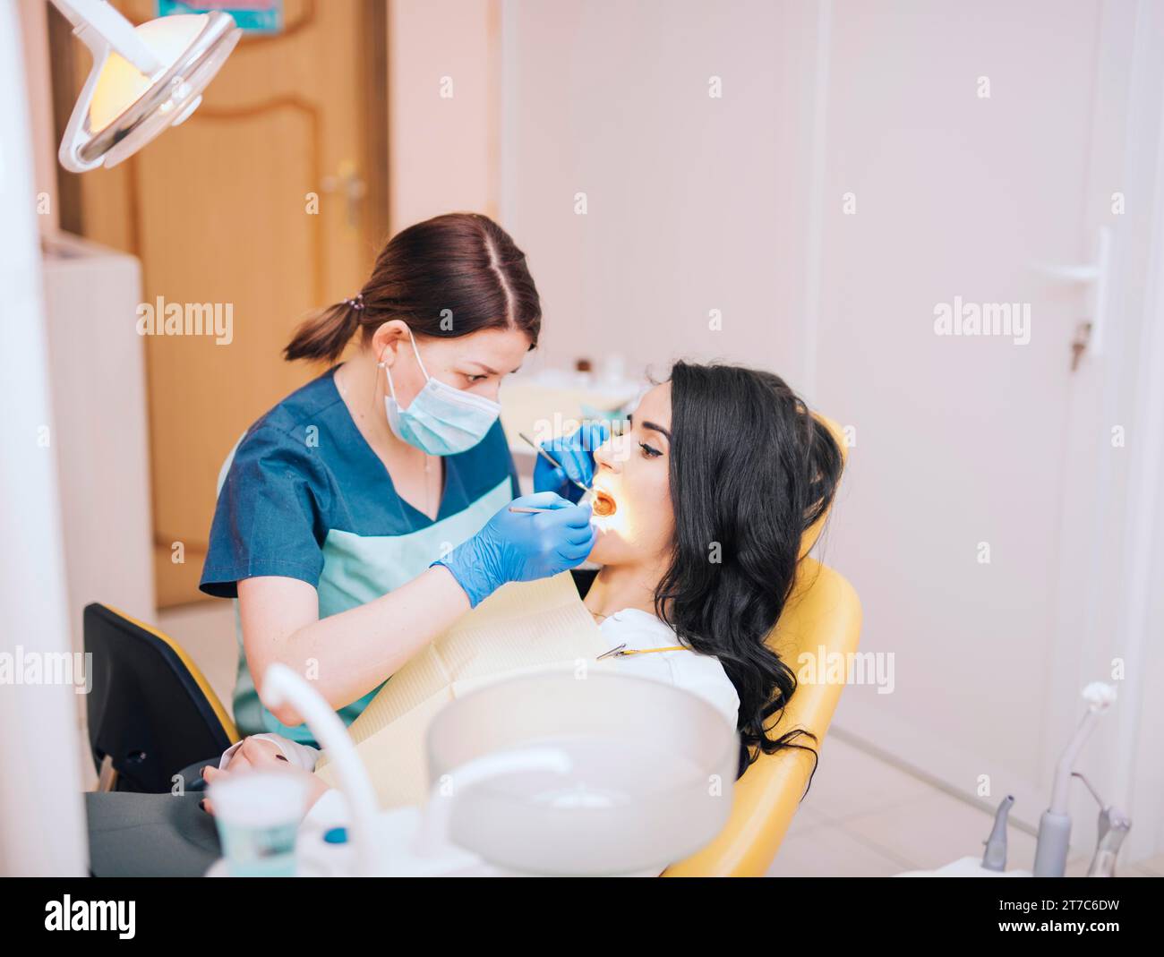 Dentist examining patients teeth clinic Stock Photo - Alamy