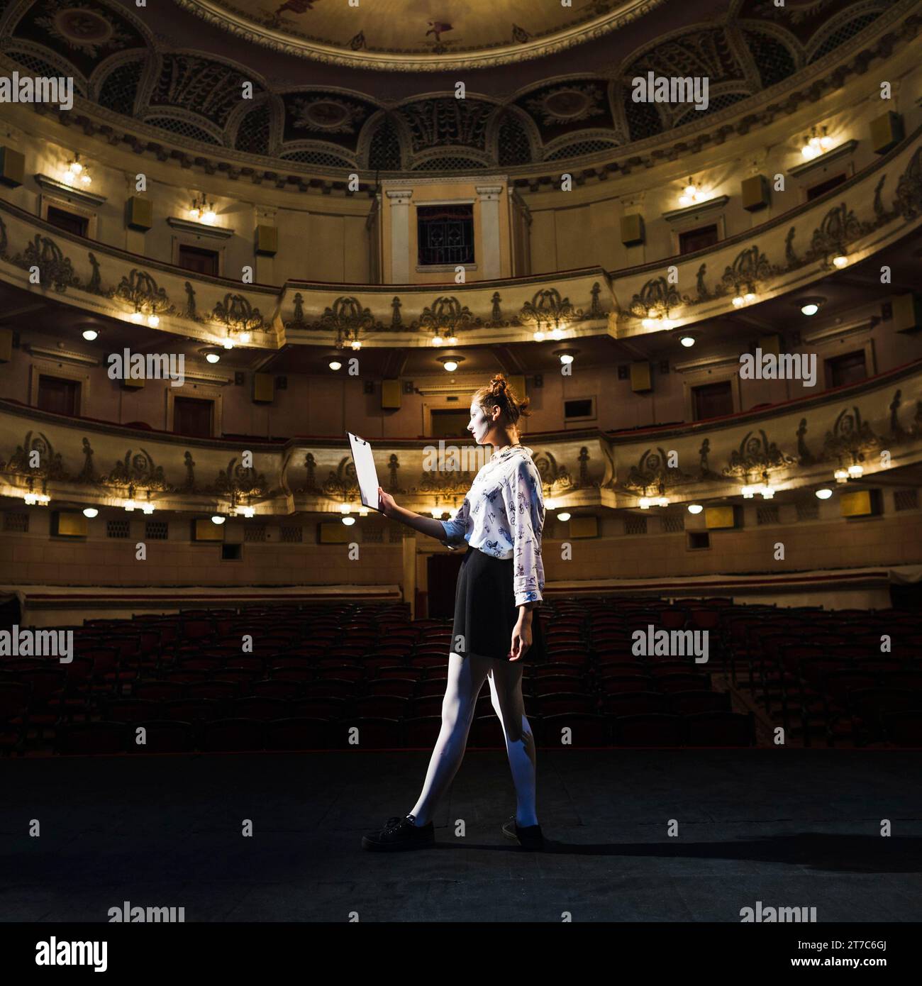 Female mime reading manuscript empty auditorium Stock Photo - Alamy