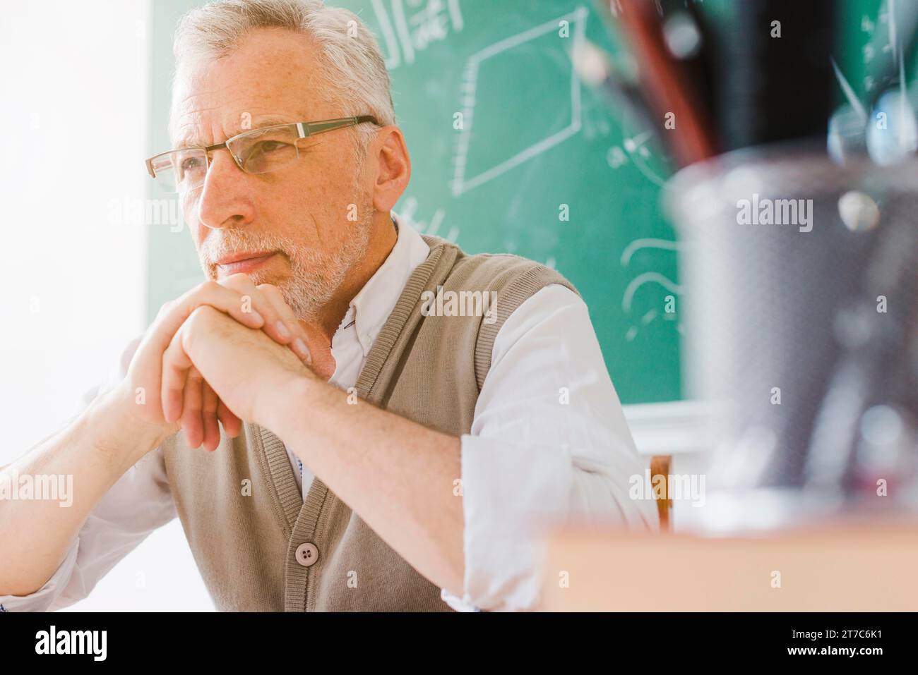 Focused old professor looking away classroom Stock Photo - Alamy