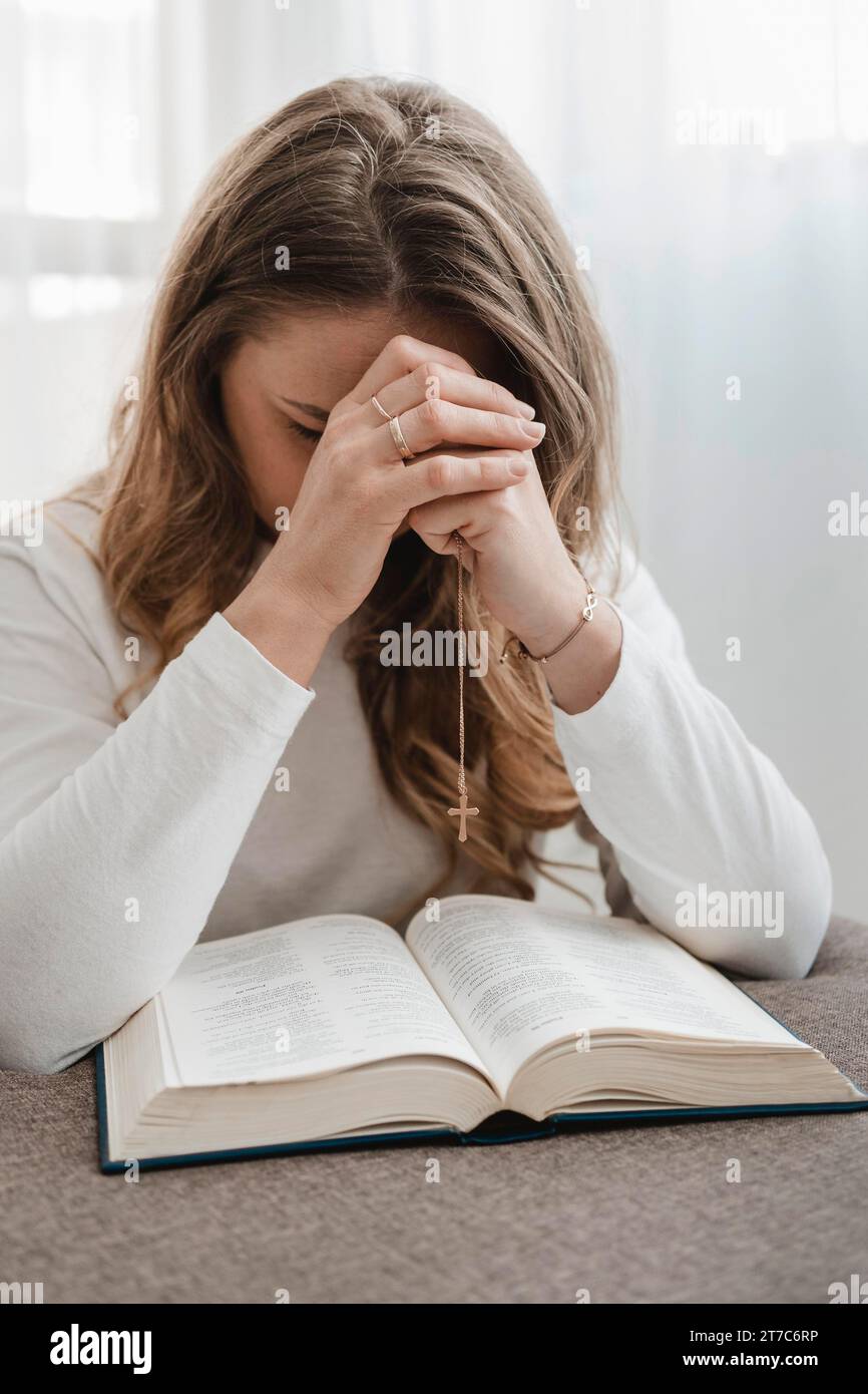 Front view woman praying home Stock Photo - Alamy