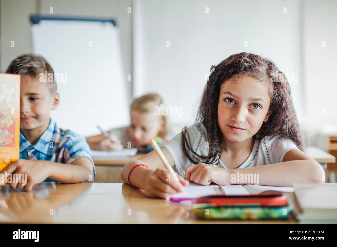 Girl sitting table writing Stock Photo - Alamy