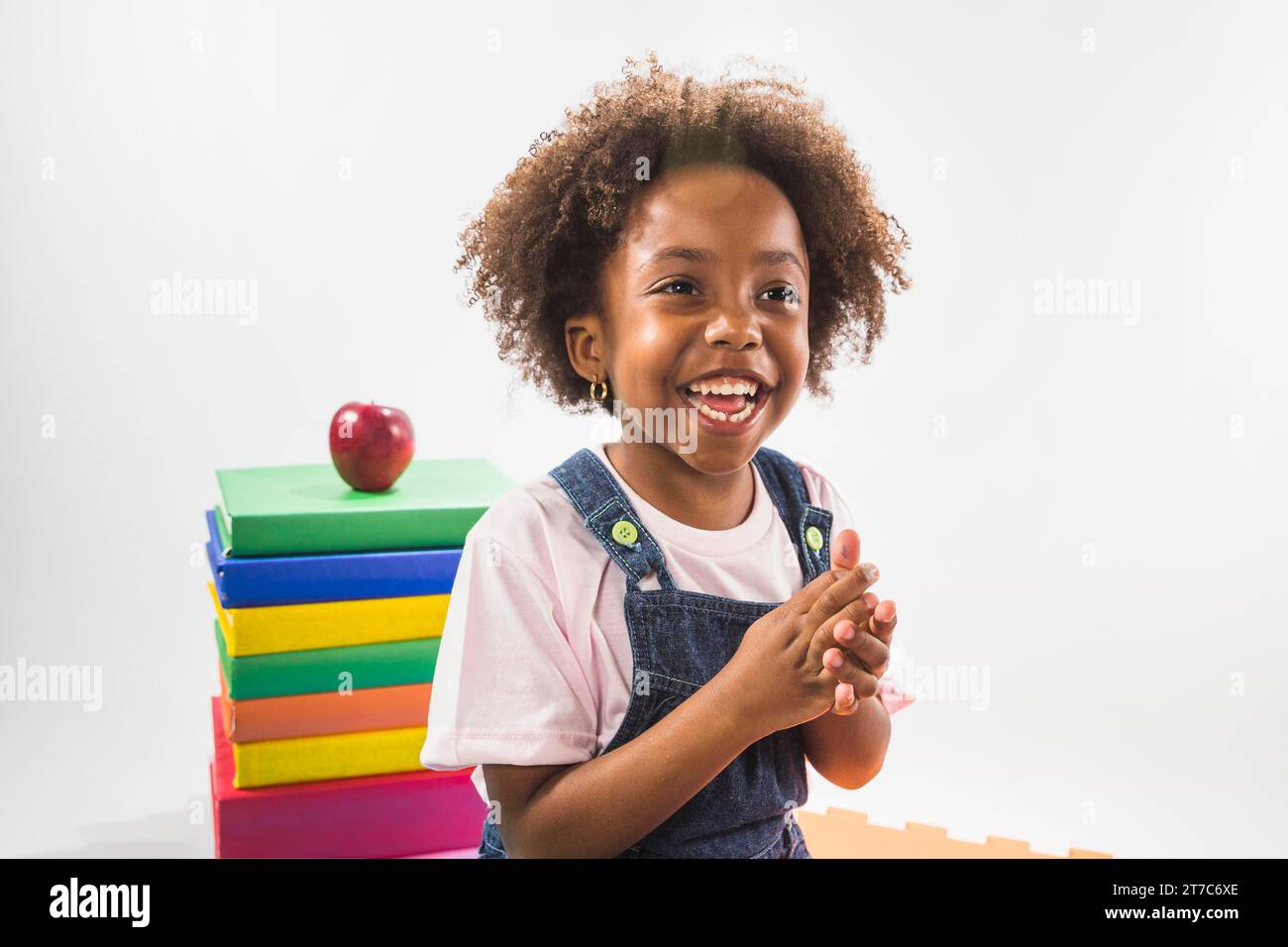 Girl with books laughing studio Stock Photo - Alamy