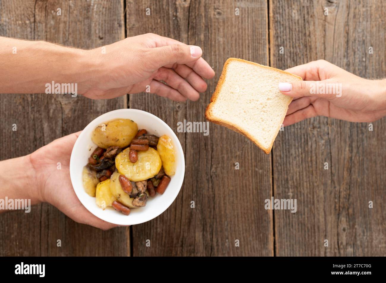 Hand giving bowl food bread needy person Stock Photo - Alamy