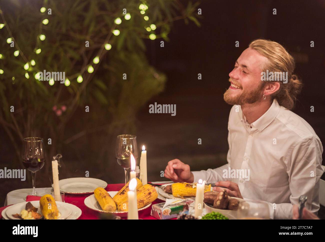 Man laughing while sitting festive table Stock Photo - Alamy