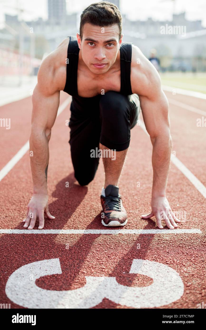 Portrait confident male athlete starting line race track Stock Photo ...
