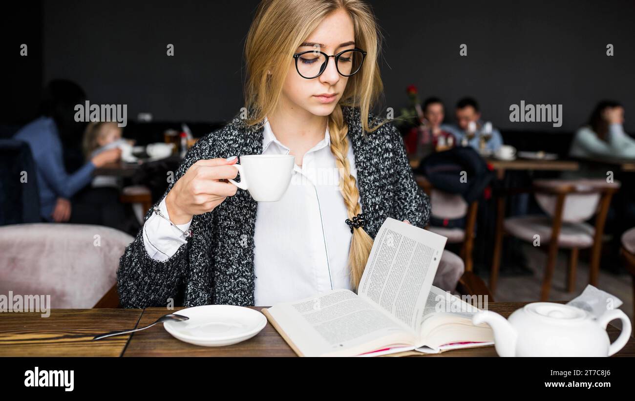 Woman drinking reading book Stock Photo - Alamy