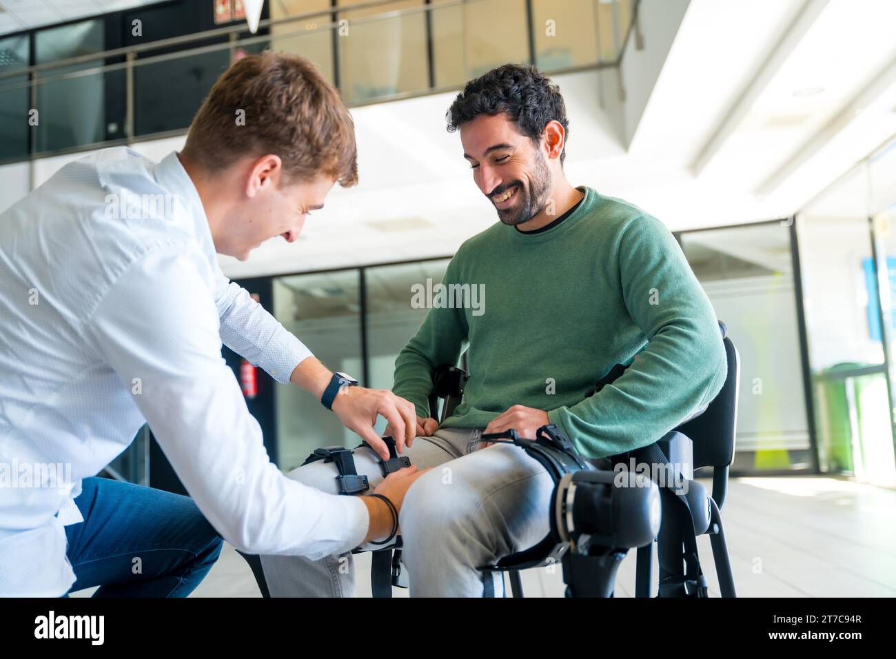Mechanical exoskeleton, physiotherapist placing the tapes on the legs ...