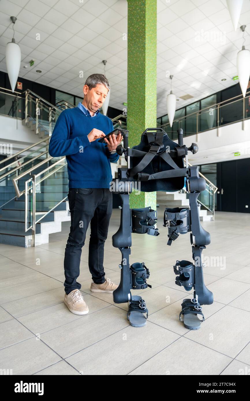 Mechanical exoskeleton computer engineer looking at the robot with a ...