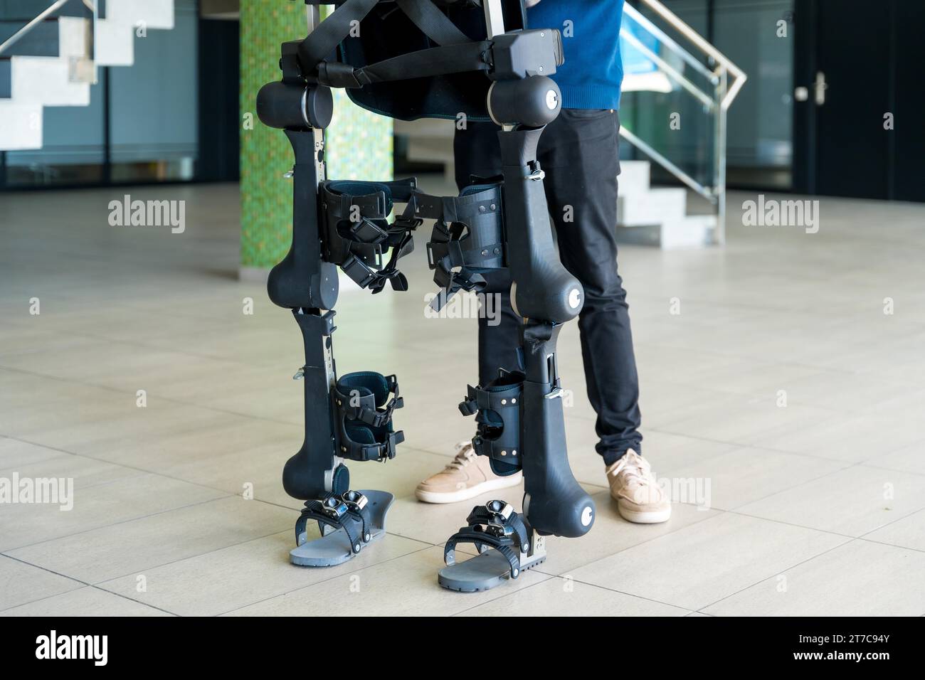 Unrecognizable computer engineer in mechanical exoskeleton looking at ...