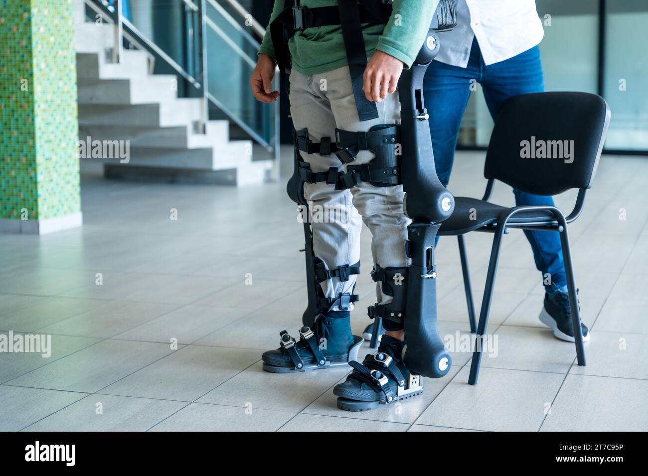 Mechanical exoskeleton, physiotherapist helped disabled person get up ...