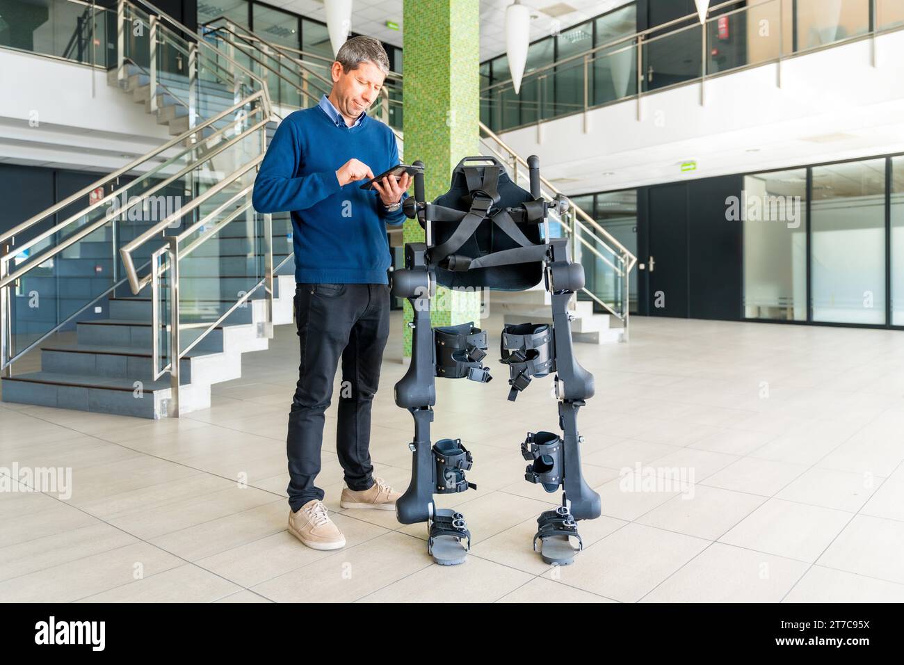 Mechanical exoskeleton computer engineer looking at the robot with a ...