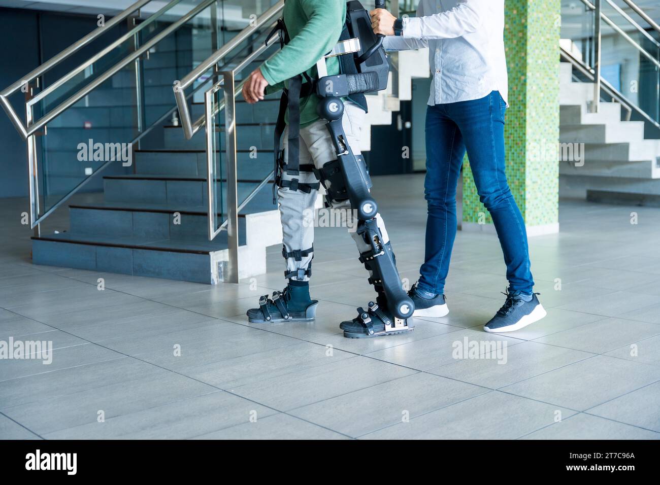 Mechanical exoskeleton, physiotherapist walking with unrecognizable ...