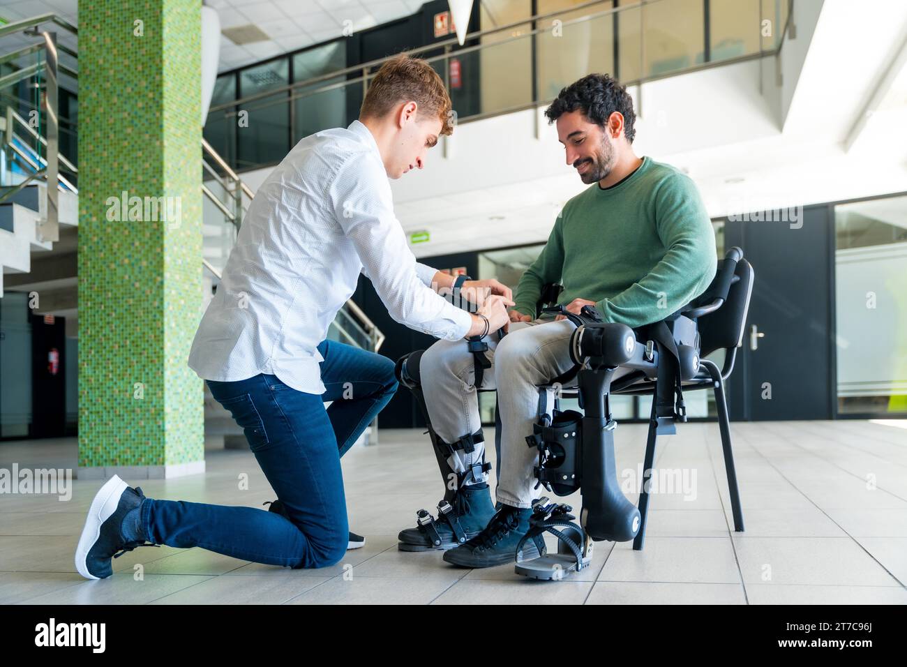 Mechanical exoskeleton, Physiotherapist placing the tapes on the knees ...