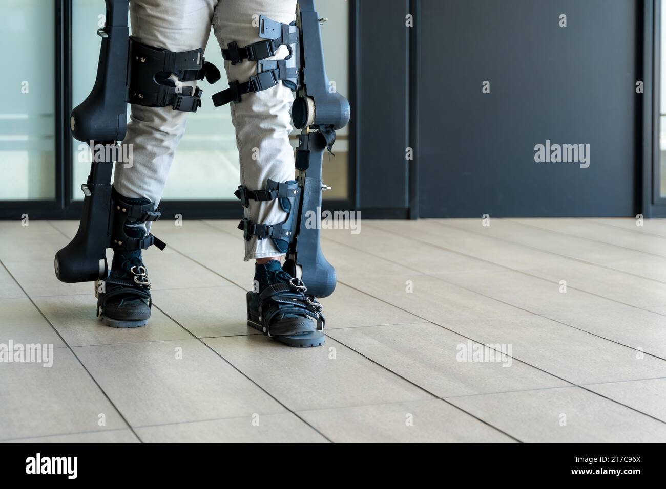 Mechanical exoskeleton, unrecognizable disabled person walking with the ...