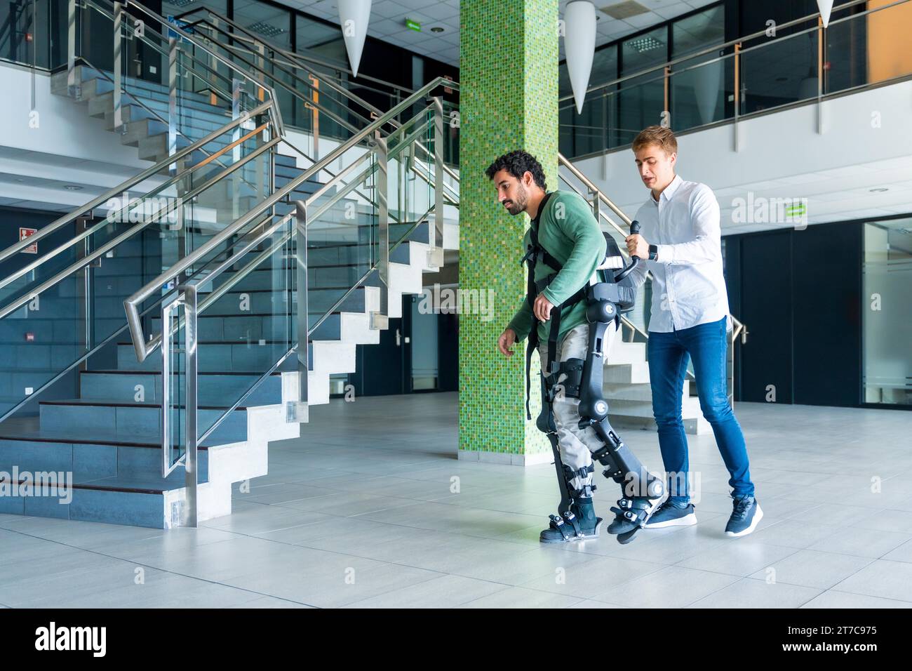 Mechanical exoskeleton, physiotherapist walking with disabled person ...