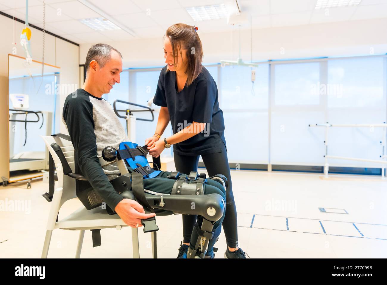 Mechanical exoskeleton. Physiotherapy assistant placing tapes on ...