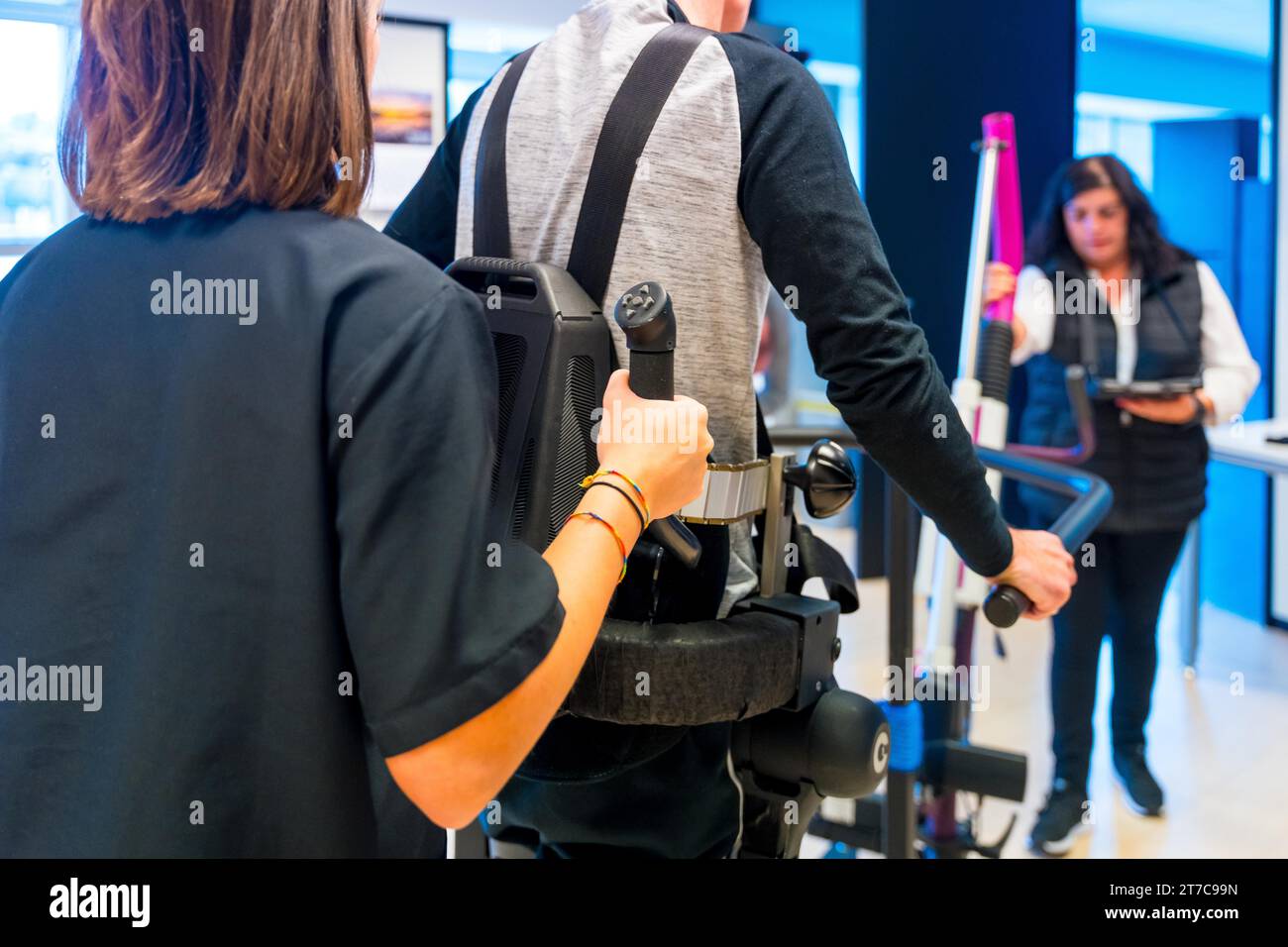 Mechanical exoskeleton. Female physiotherapy medical assistant helping ...
