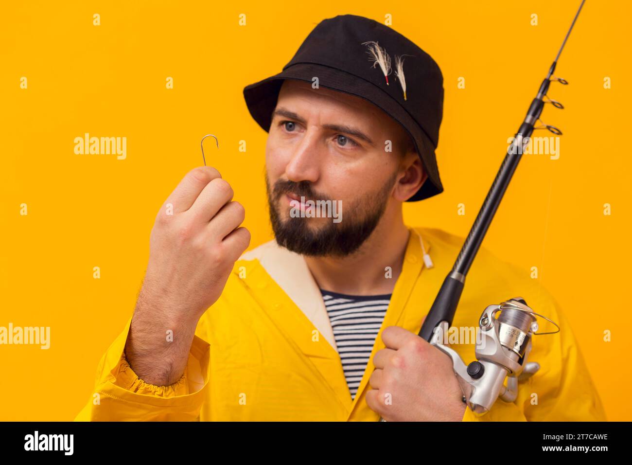 Front view fisherman holding fishing rod looking hook Stock Photo - Alamy