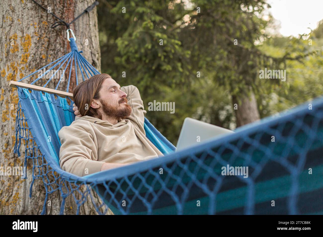 Man hammock enjoying nature with laptop Stock Photo - Alamy