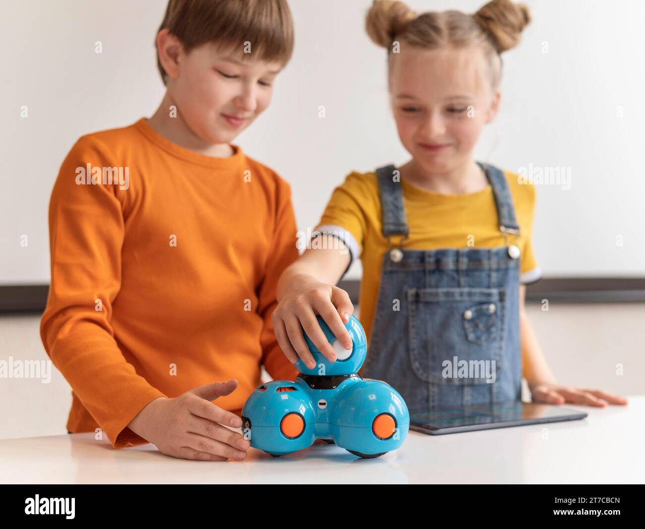 Medium shot smiley kids learning Stock Photo - Alamy