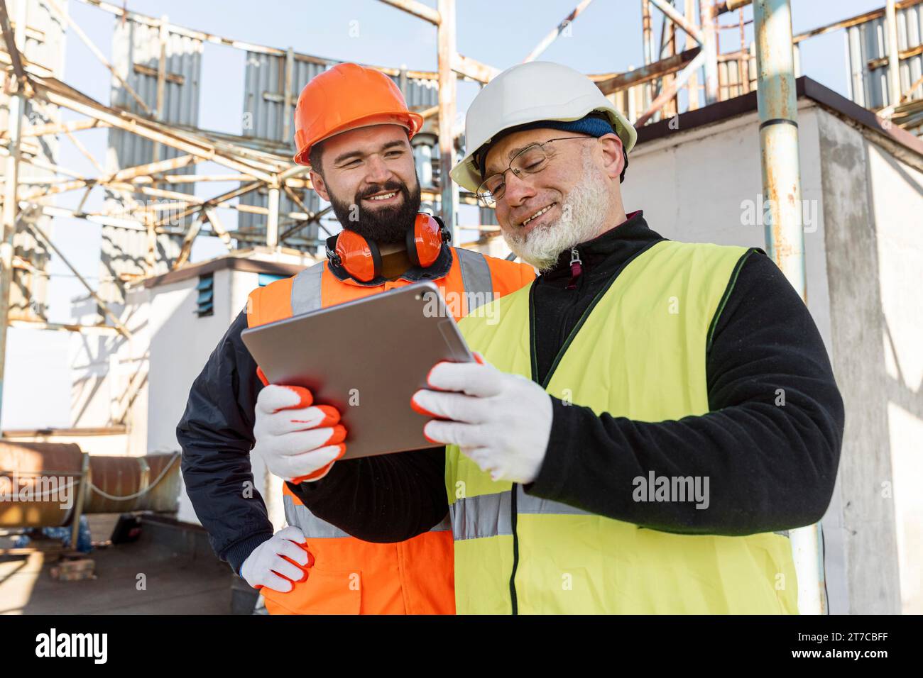 Medium shot smiley men with tablet Stock Photo - Alamy