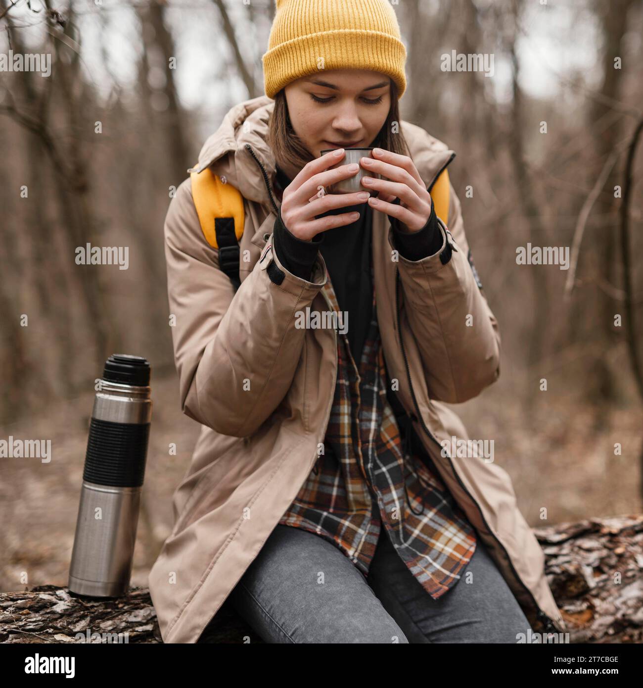 Medium shot woman sitting with cup Stock Photo - Alamy