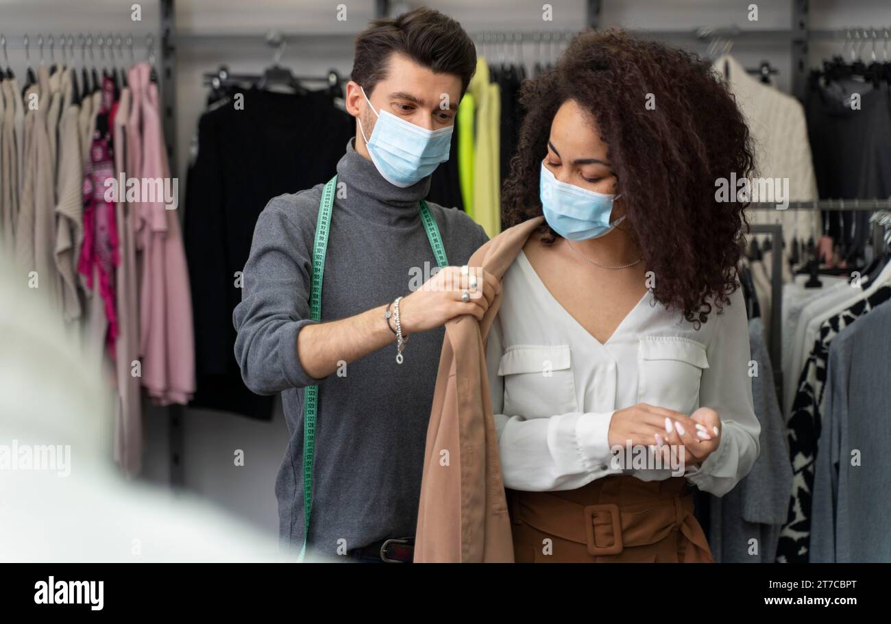Personal shopper helping cutomer choose clothes Stock Photo - Alamy
