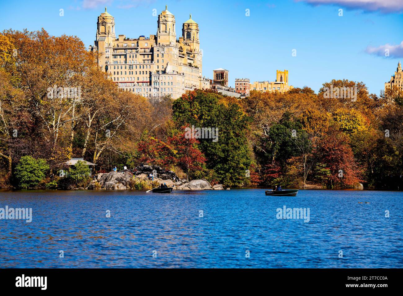 Skyscrapers loom above the multicolored trees of autumn in Central Park ...