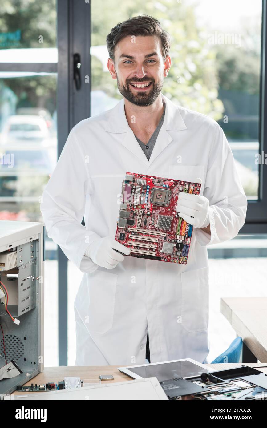 Portrait smiling young man holding computer motherboard Stock Photo - Alamy