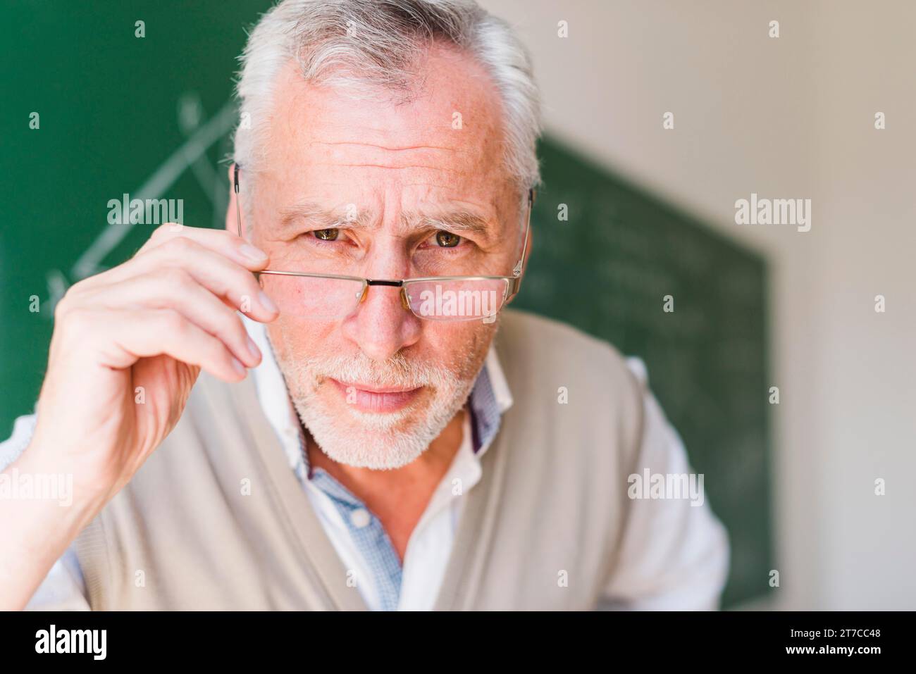 Senior professor putting glasses classroom Stock Photo - Alamy