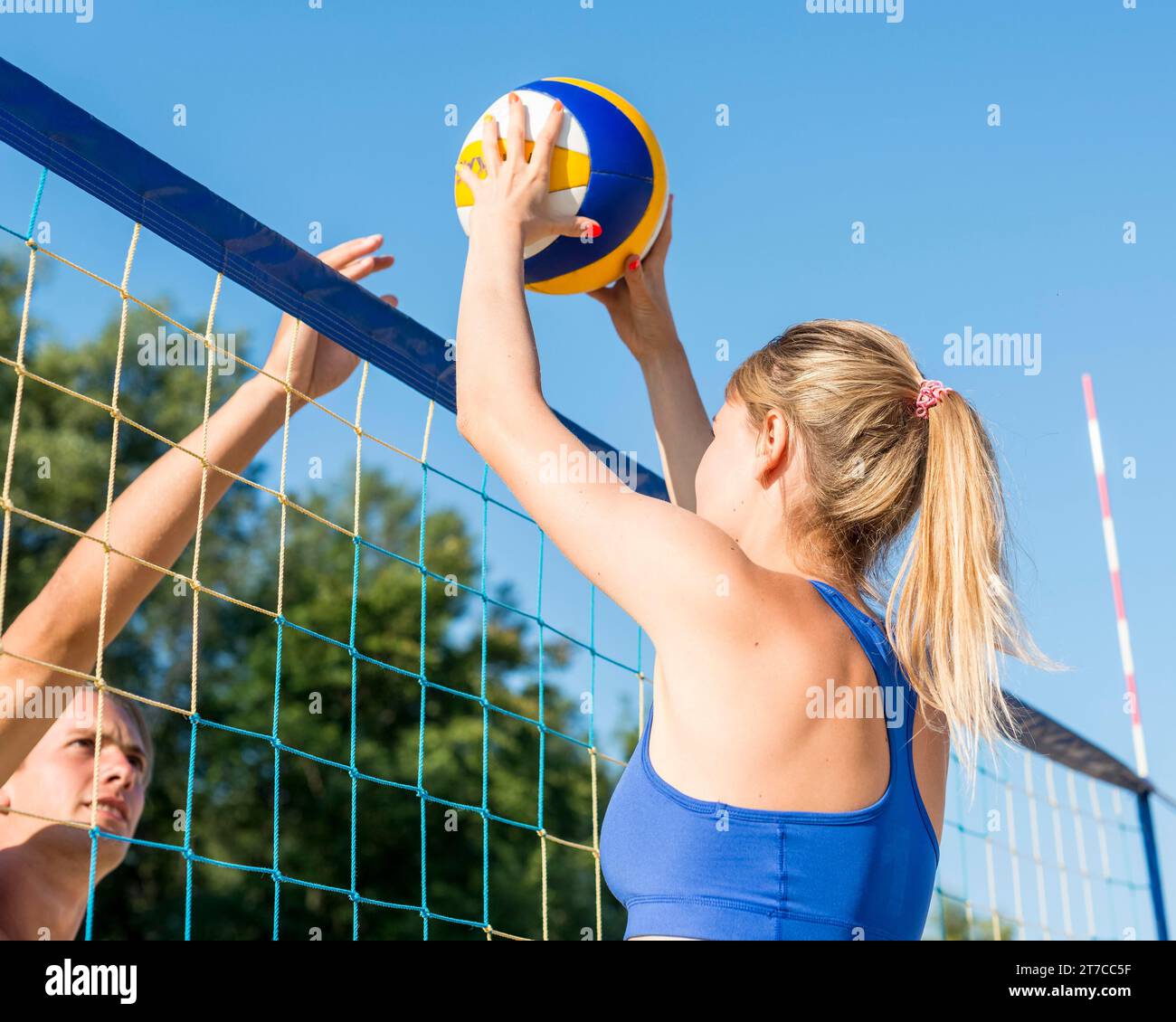 Side view man woman playing beach volleyball Stock Photo - Alamy