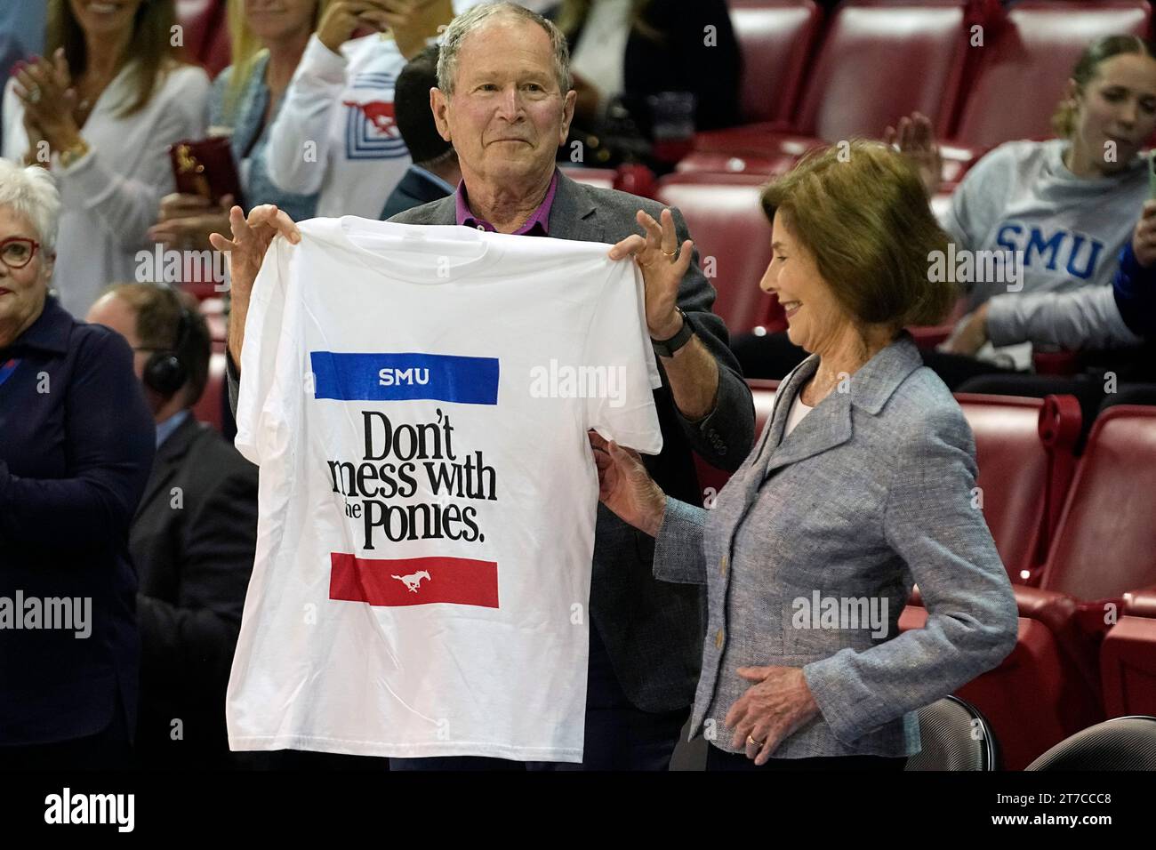 Former United States President George W. Bush, left, holds up a shirt ...