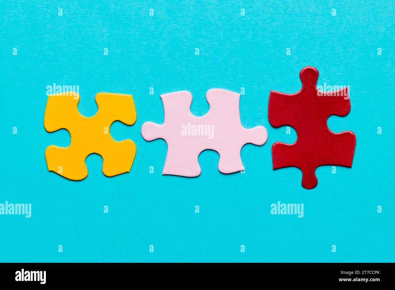 Yellow pink red jigsaw puzzle piece blue textured background Stock ...