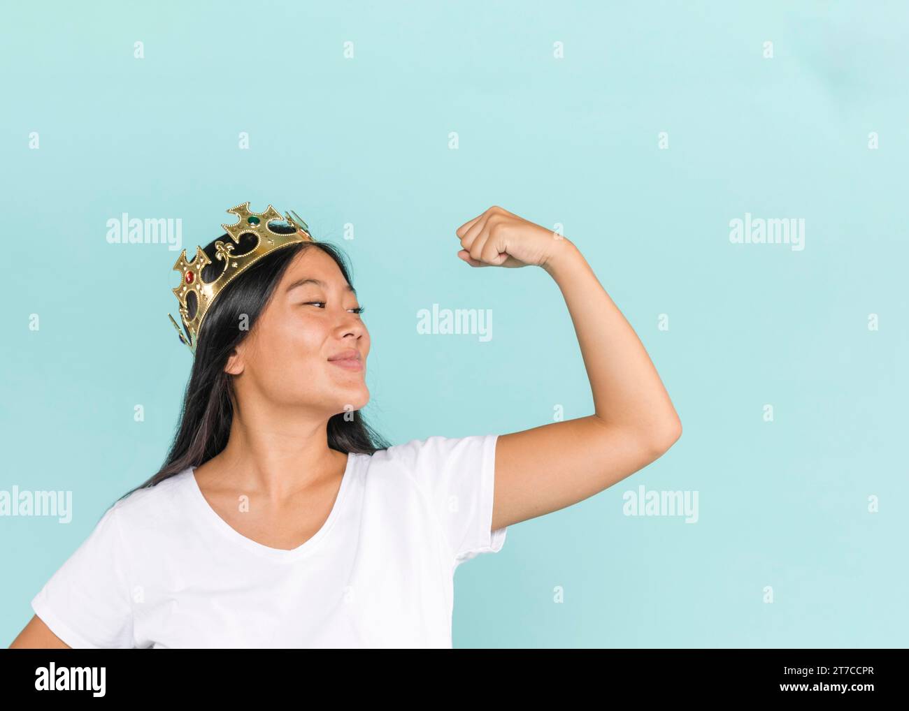Woman wearing crown raising her arm Stock Photo - Alamy
