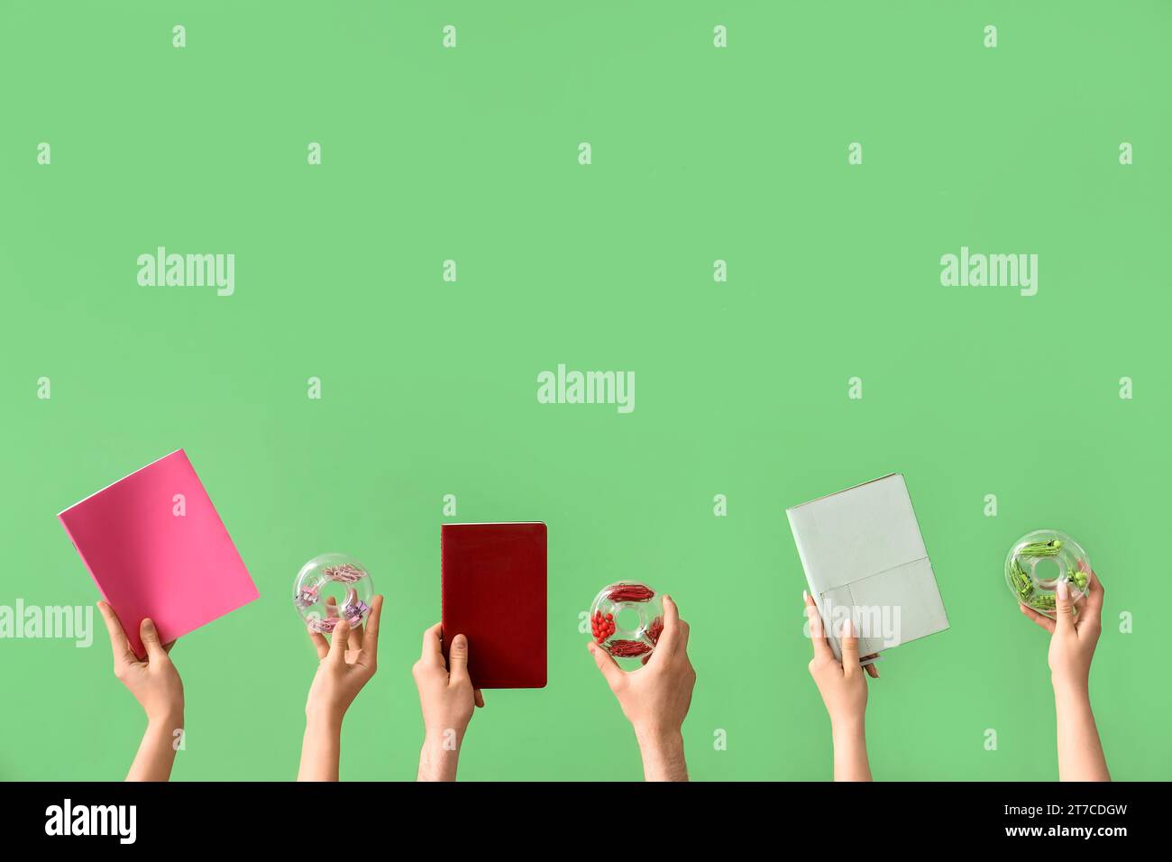 Hands holding school supplies on green background Stock Photo - Alamy