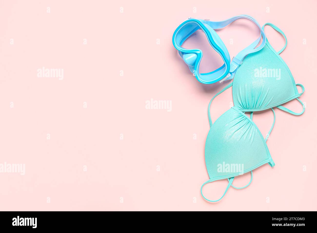 Blue swimming mask and bikini bra on pink background Stock Photo - Alamy